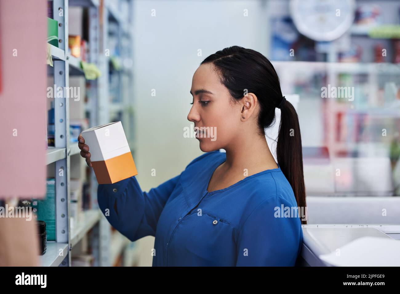 This looks like the correct meds. a young woman shopping at a pharmacy ...