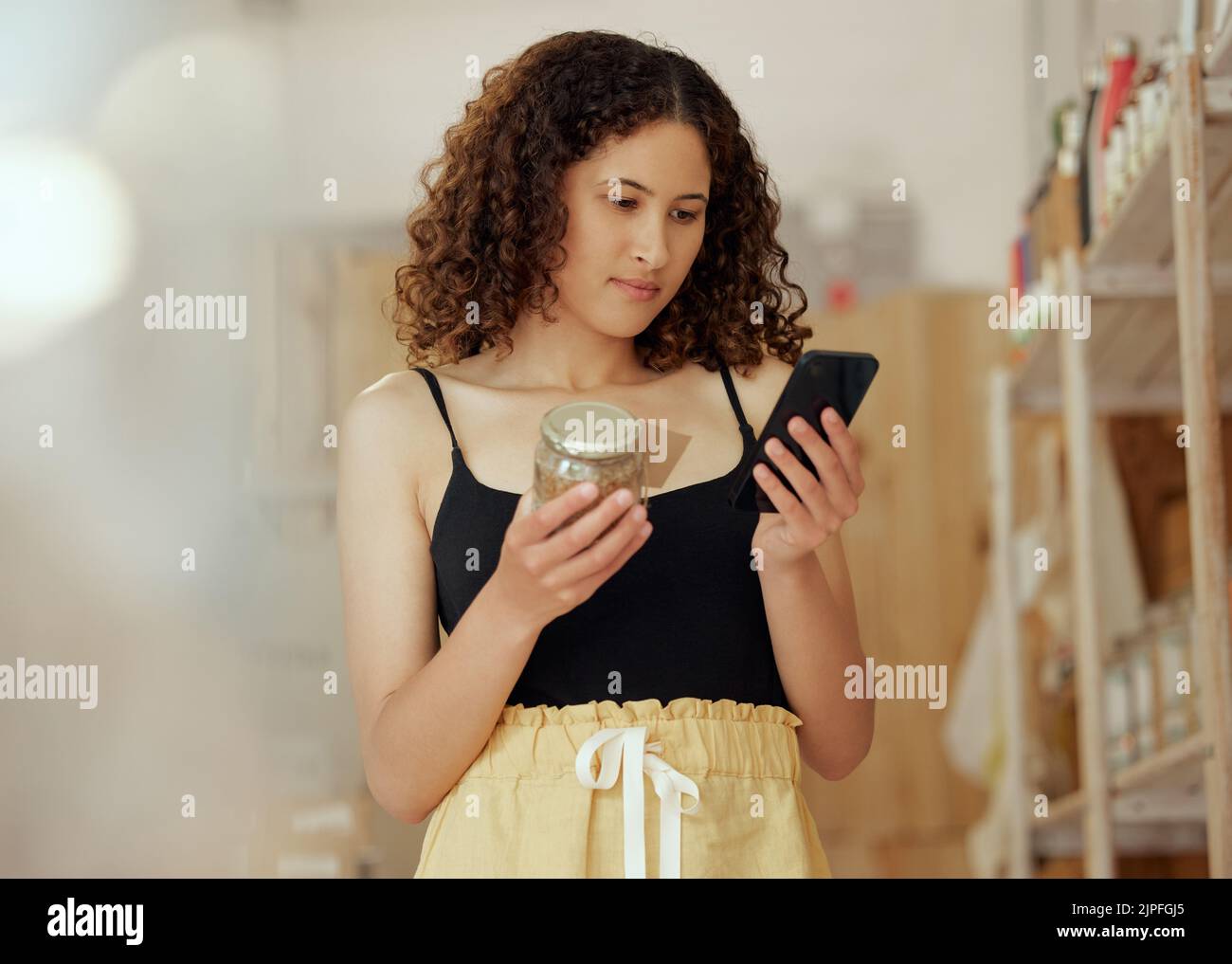 Customer shopping, browsing phone and picking supermarket product ...