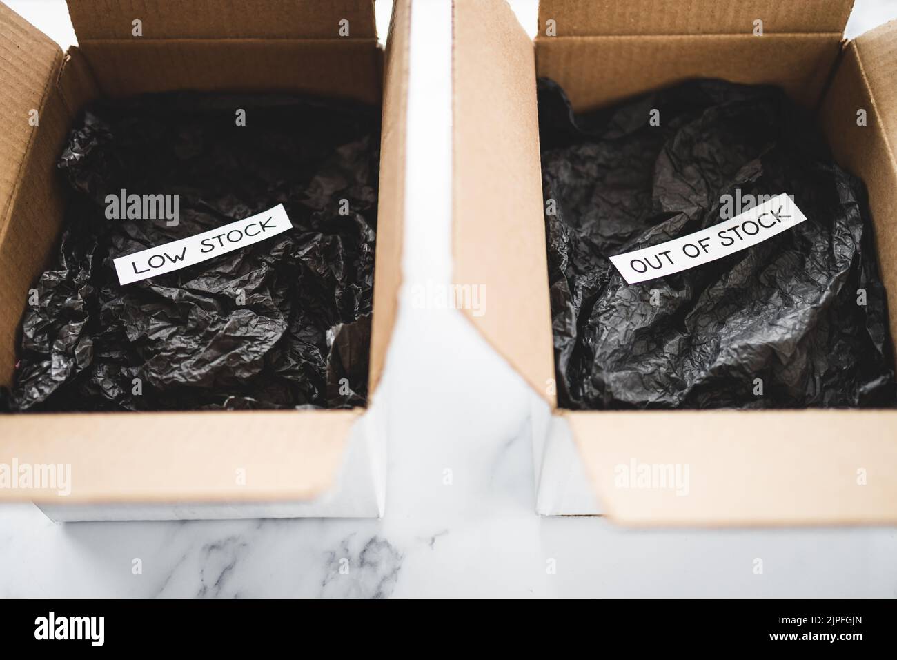Low stock and out of stock texts inside of empty delivery parcels with ...