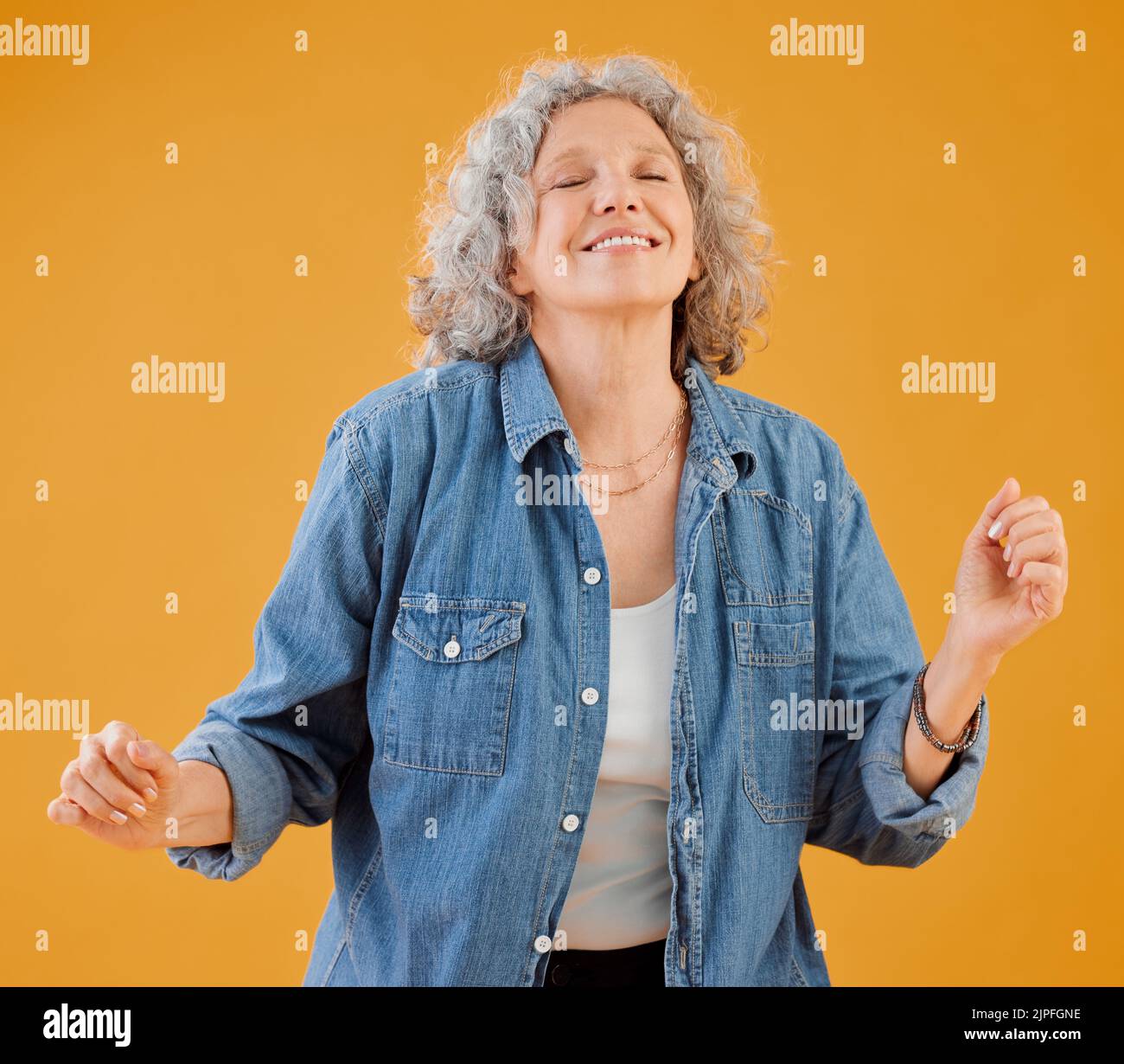 Smiling mature woman celebrating, dancing and being carefree, happy and ...