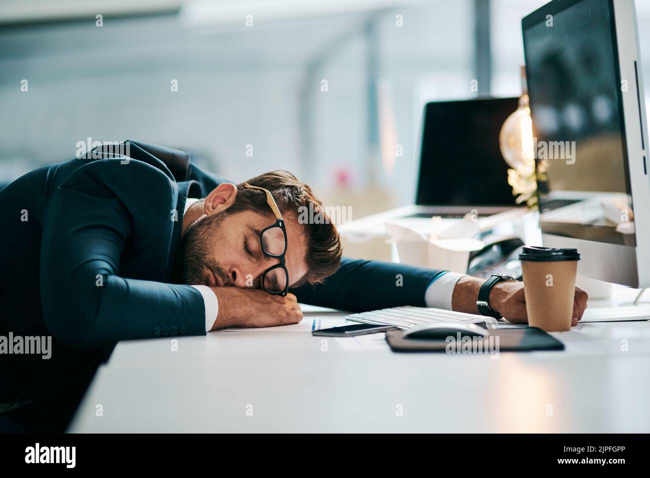 The busy day has knocked him out. a tired young businessman sleeping on ...