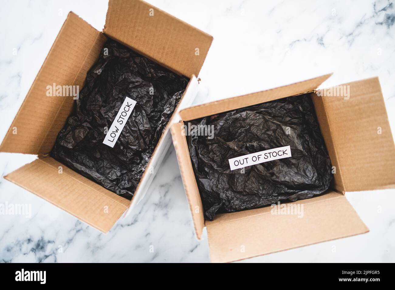 Low stock and out of stock texts inside of empty delivery parcels with ...