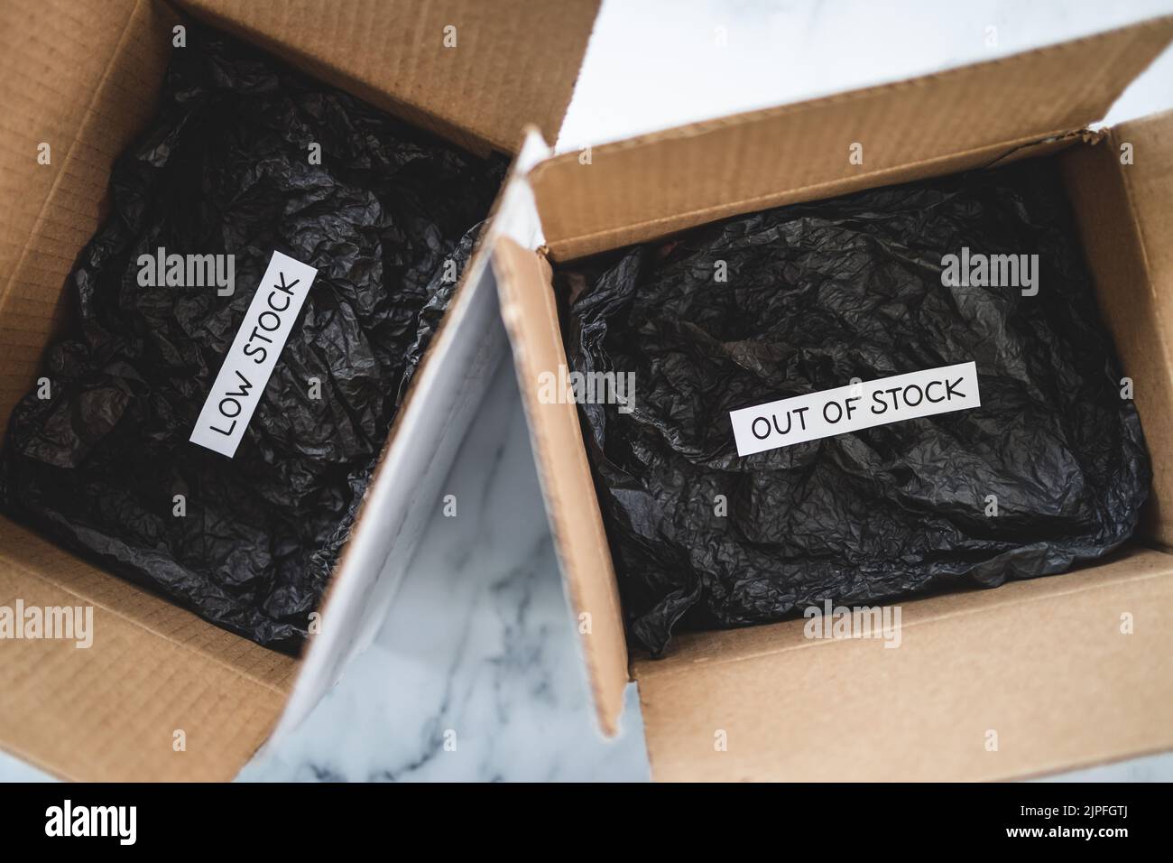 Low stock and out of stock texts inside of empty delivery parcels with ...
