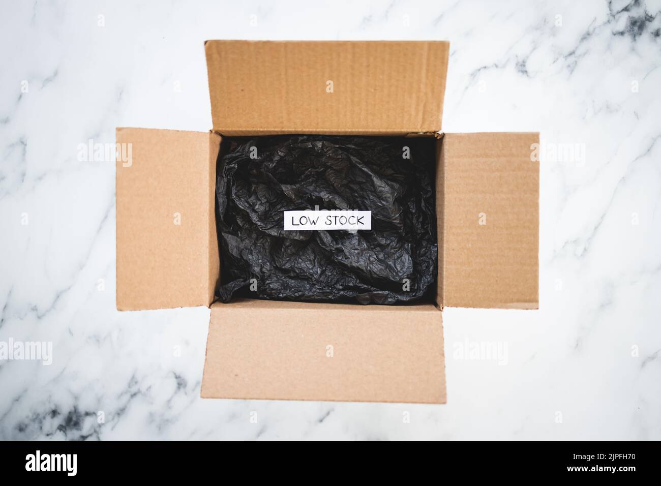 Low stock text inside of empty delivery parcel with black padding on ...
