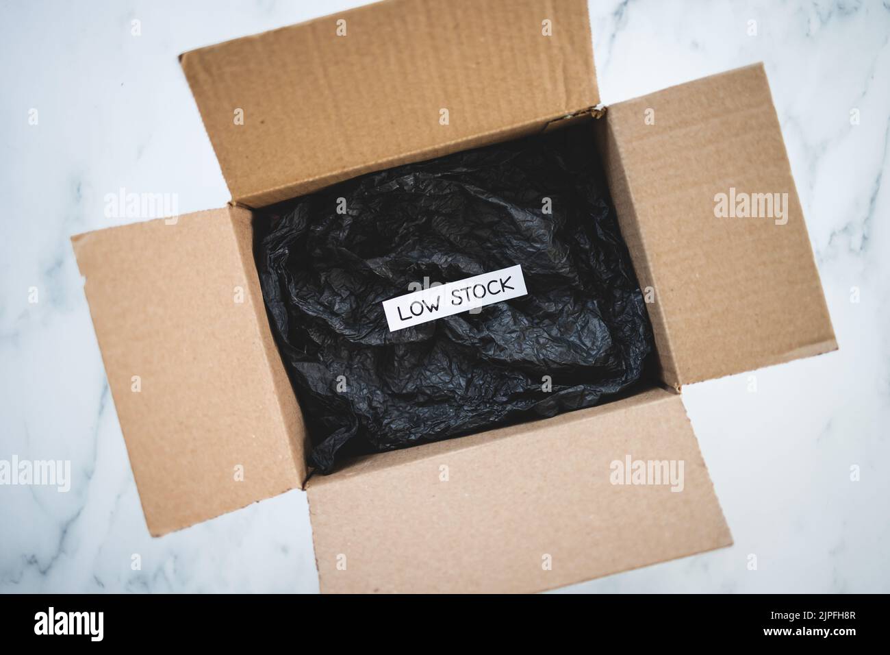 Low stock text inside of empty delivery parcel with black padding on ...