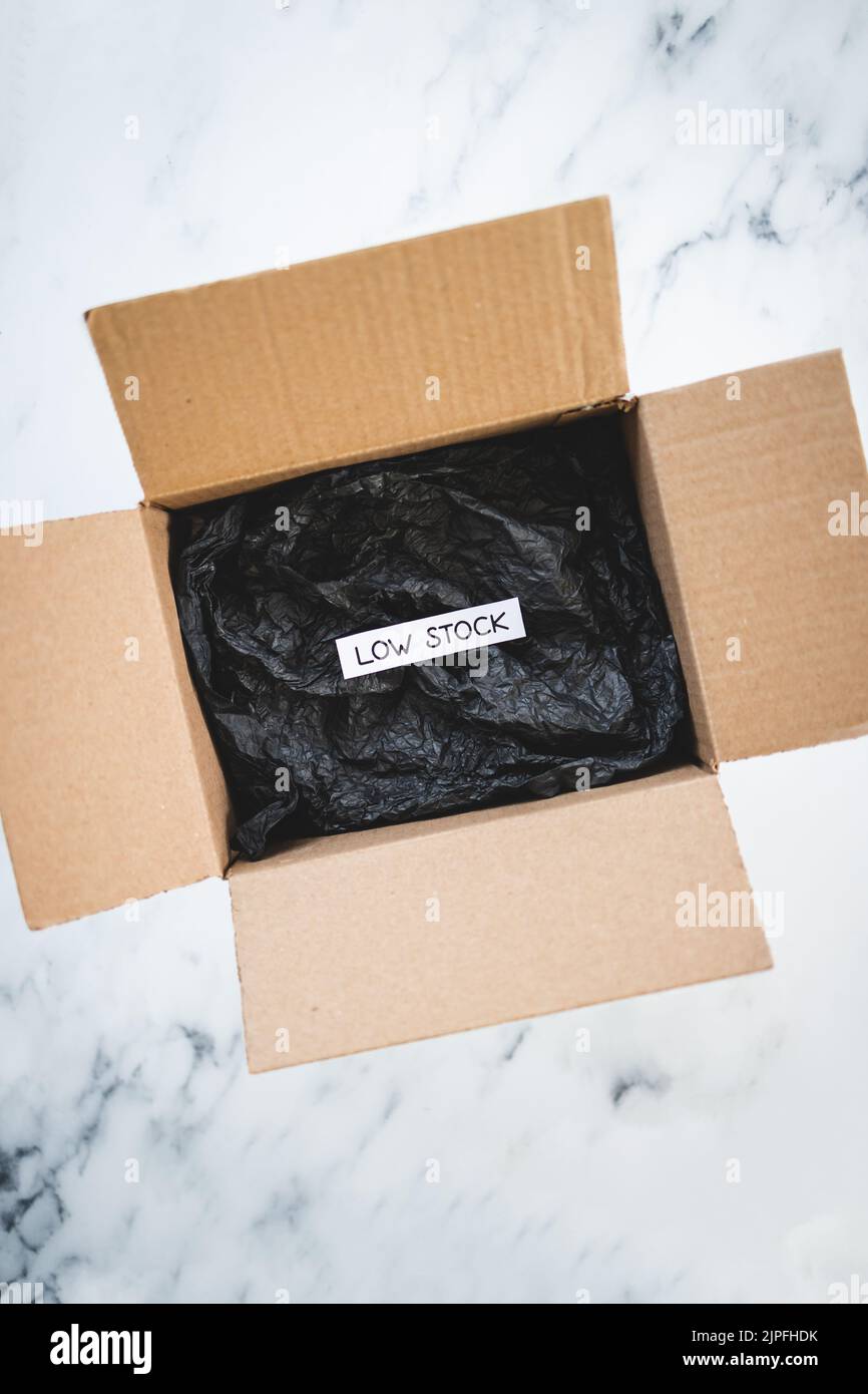 Low stock text inside of empty delivery parcel with black padding on ...