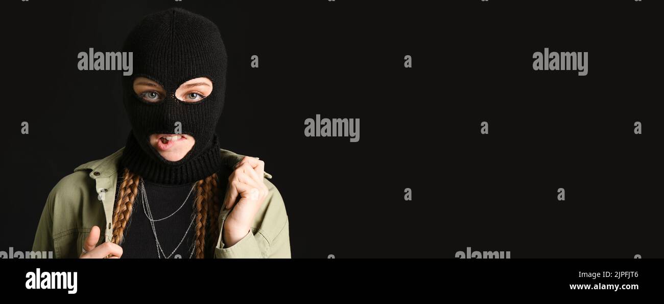 Young woman in balaclava on black background with space for text Stock ...
