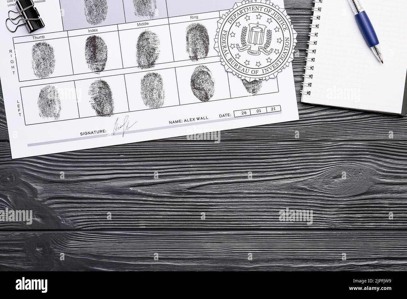 Paper sheet with finger prints, seal of FBI and notebook on dark wooden ...