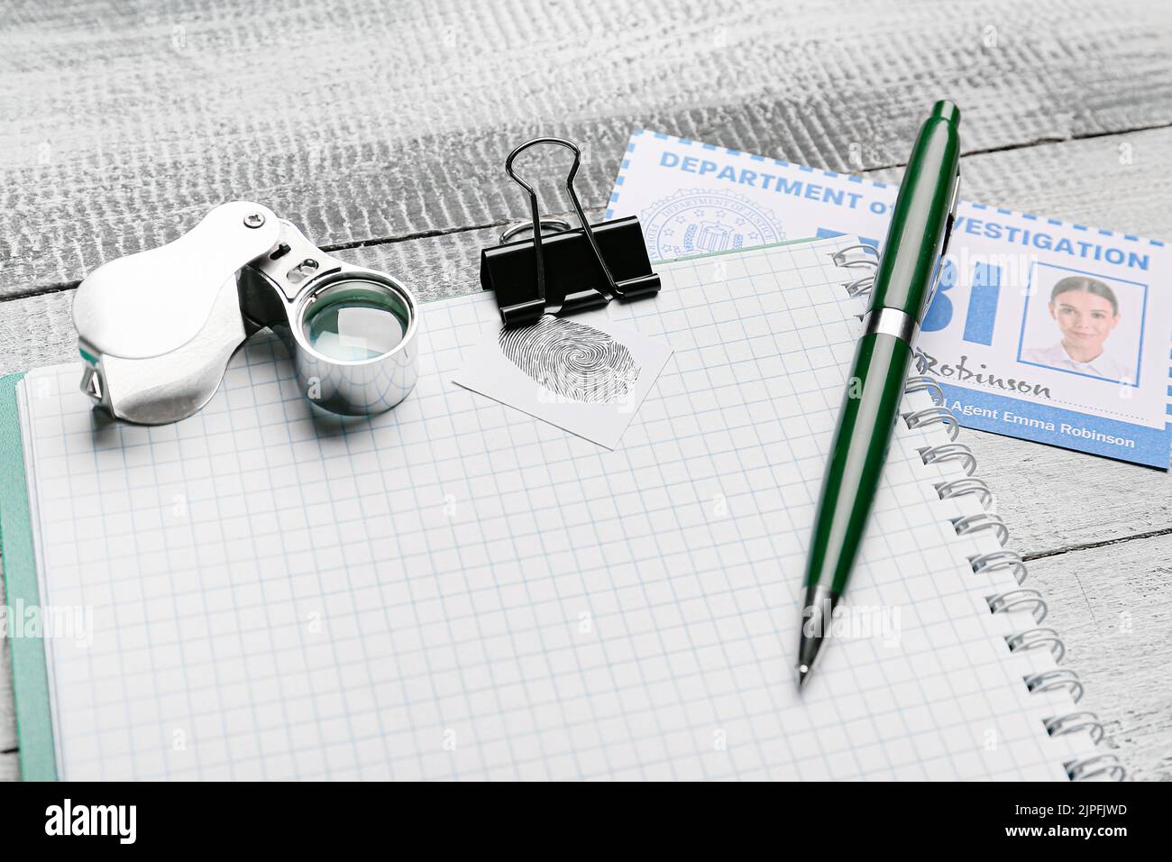 Notebook with magnifier and document of FBI agent on wooden background ...