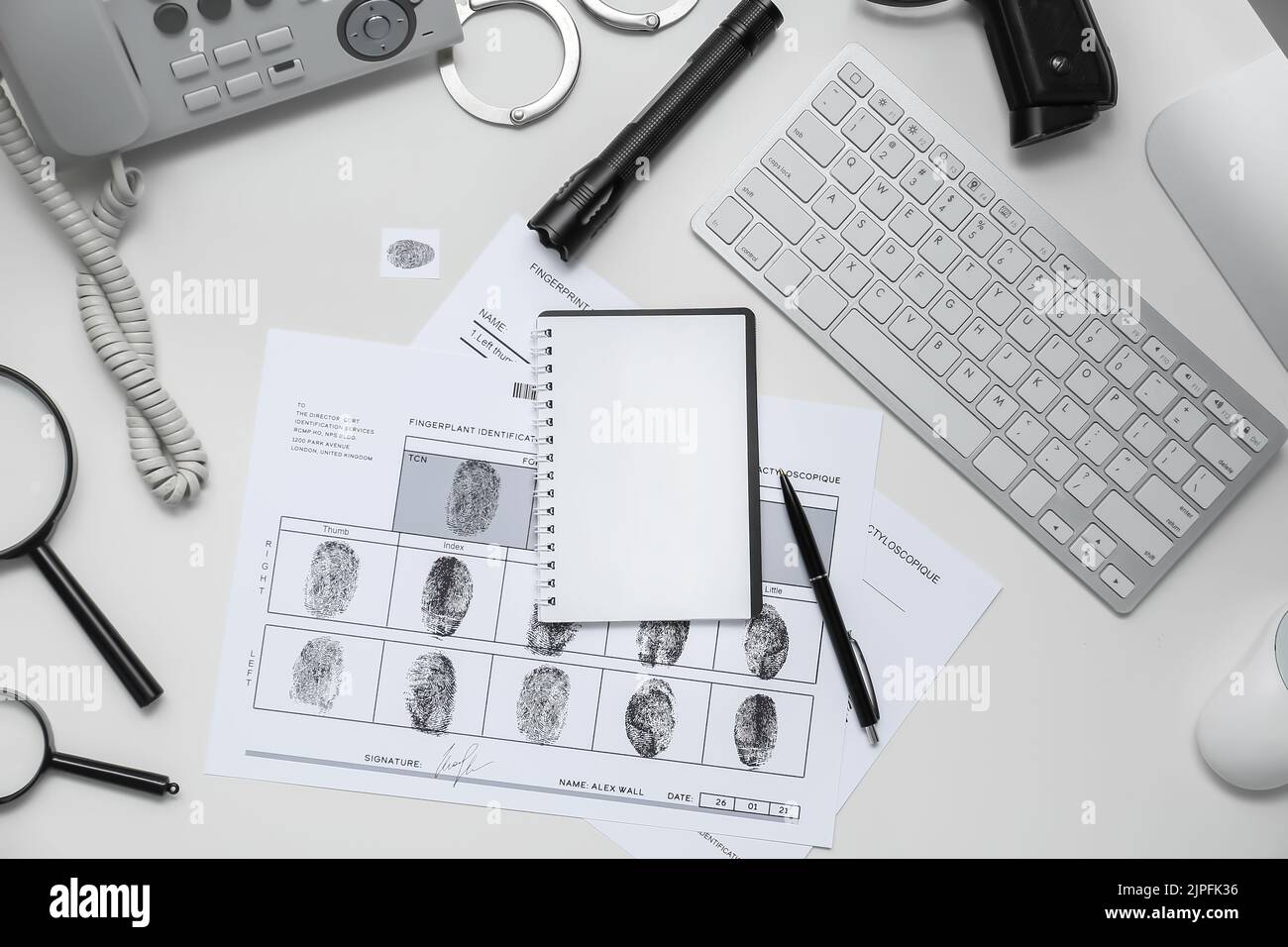 Notebook, paper sheet with finger prints and computer at workplace of ...
