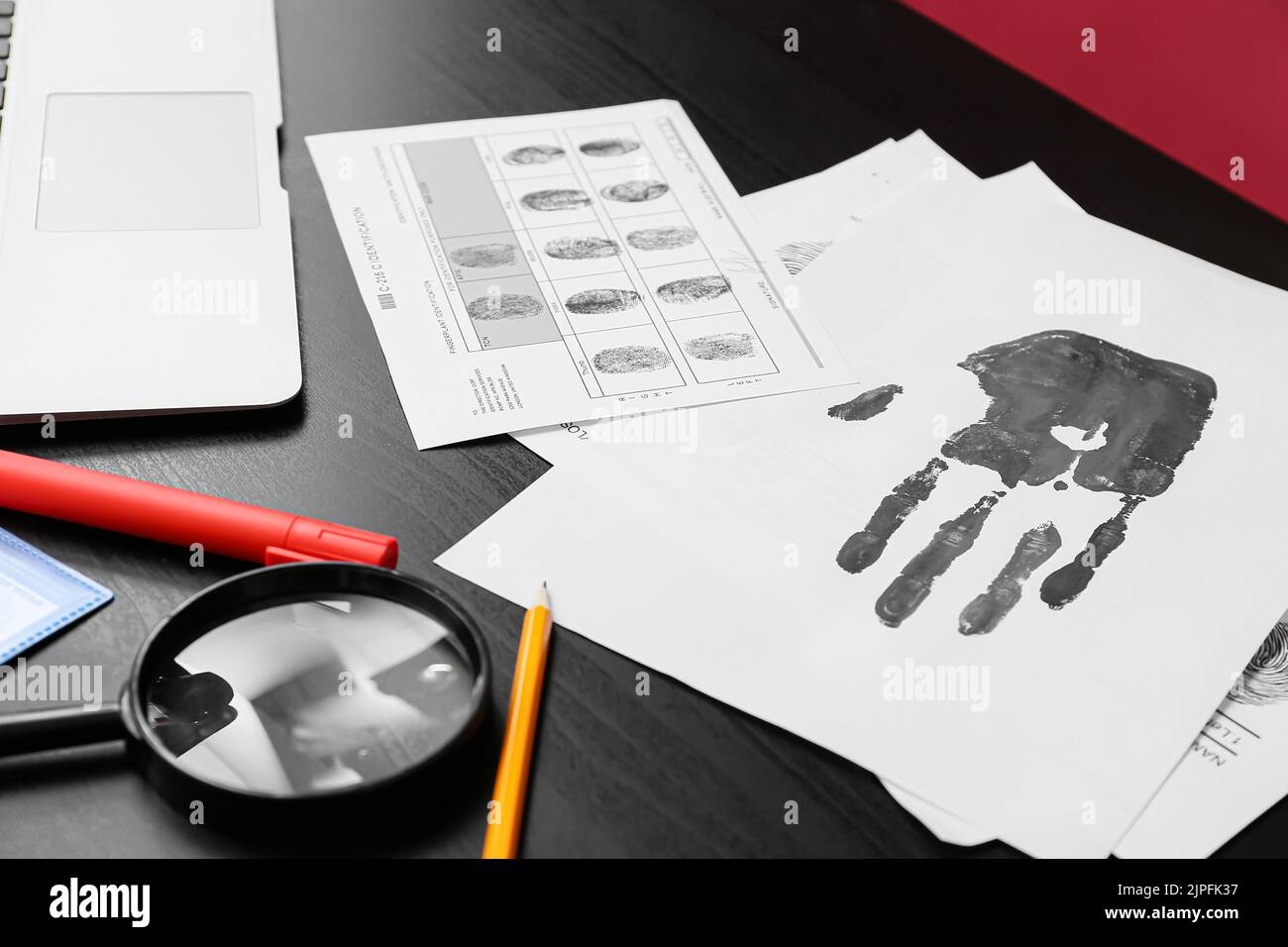 Paper sheets with different prints, magnifier and laptop at workplace ...