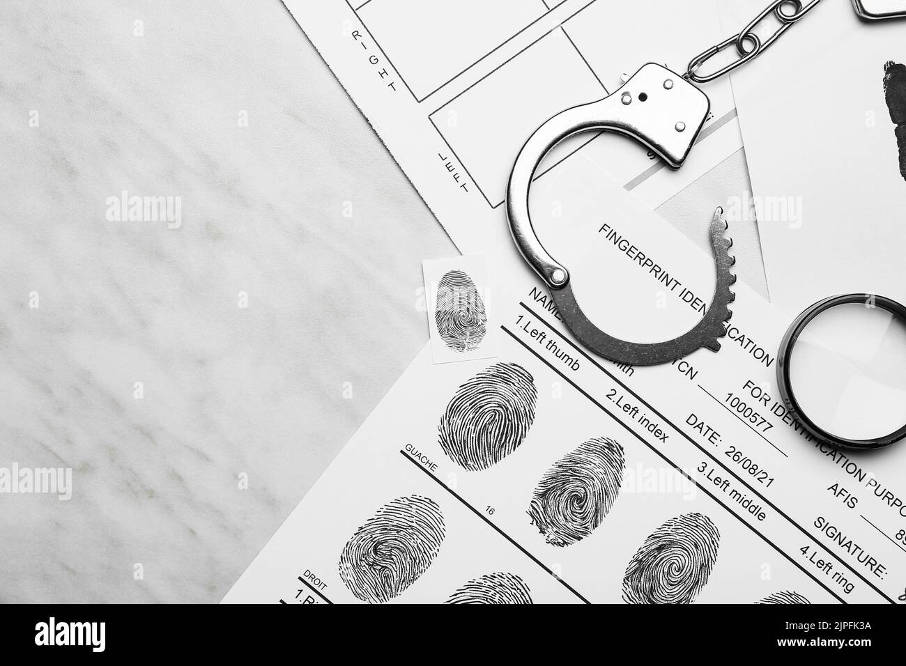 Paper sheets with finger prints and handcuffs on white background Stock ...