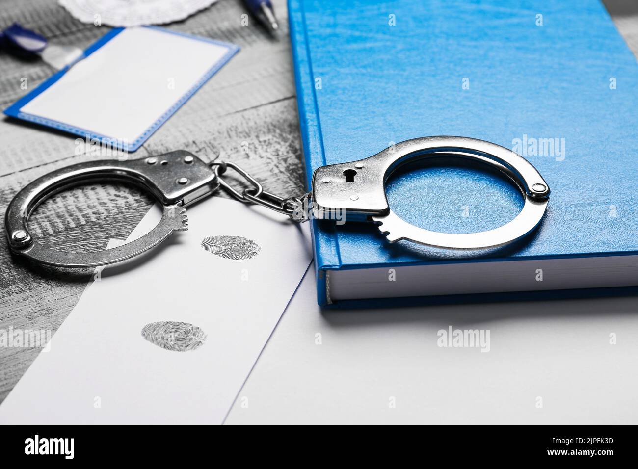Paper sheet with finger prints, handcuffs and notebook on table Stock ...