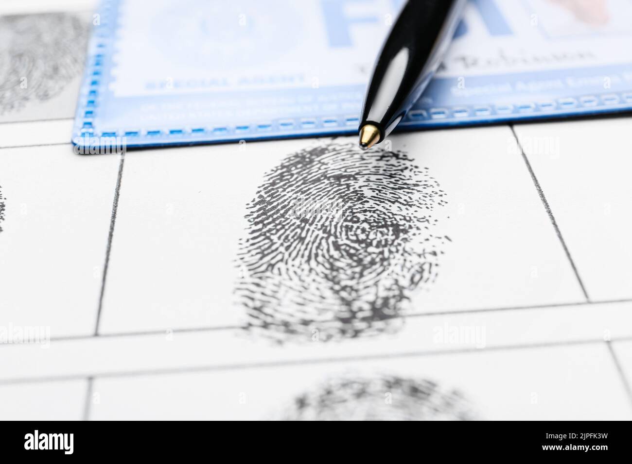 Paper sheet with finger prints, pen and FBI agent's document, closeup ...