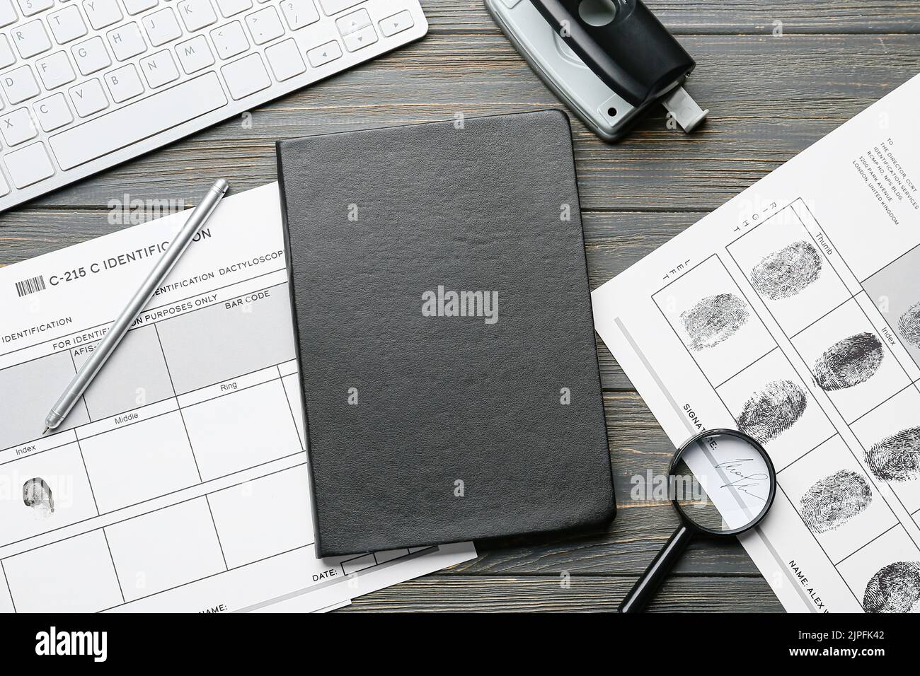 Paper sheets with finger prints, notebook and computer at workplace of ...