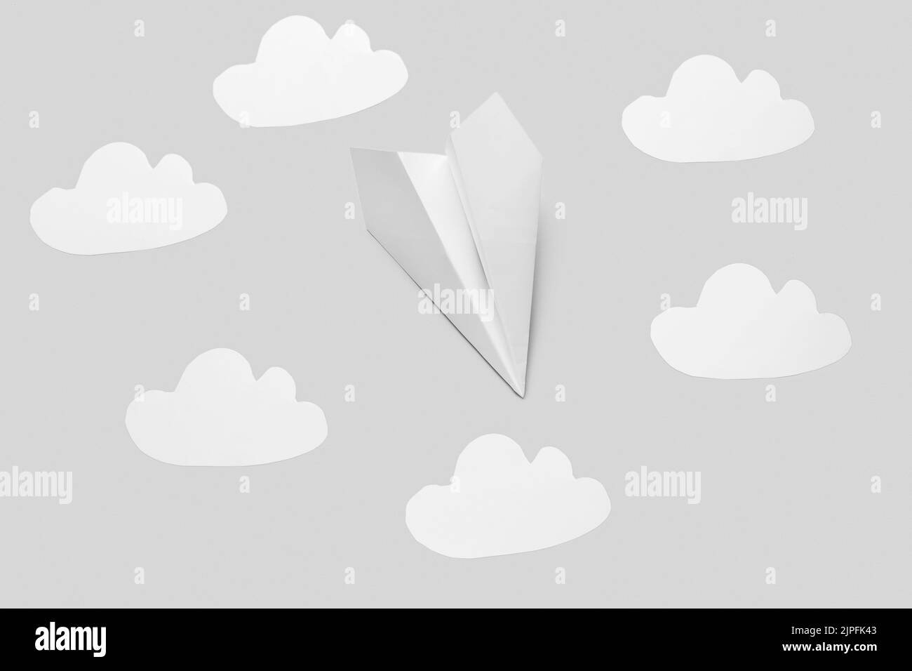 Paper plane and clouds on grey background Stock Photo - Alamy