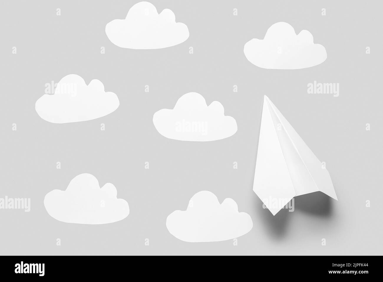 Paper plane and clouds on grey background Stock Photo - Alamy