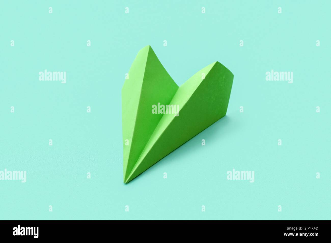 Green paper plane on color background Stock Photo - Alamy