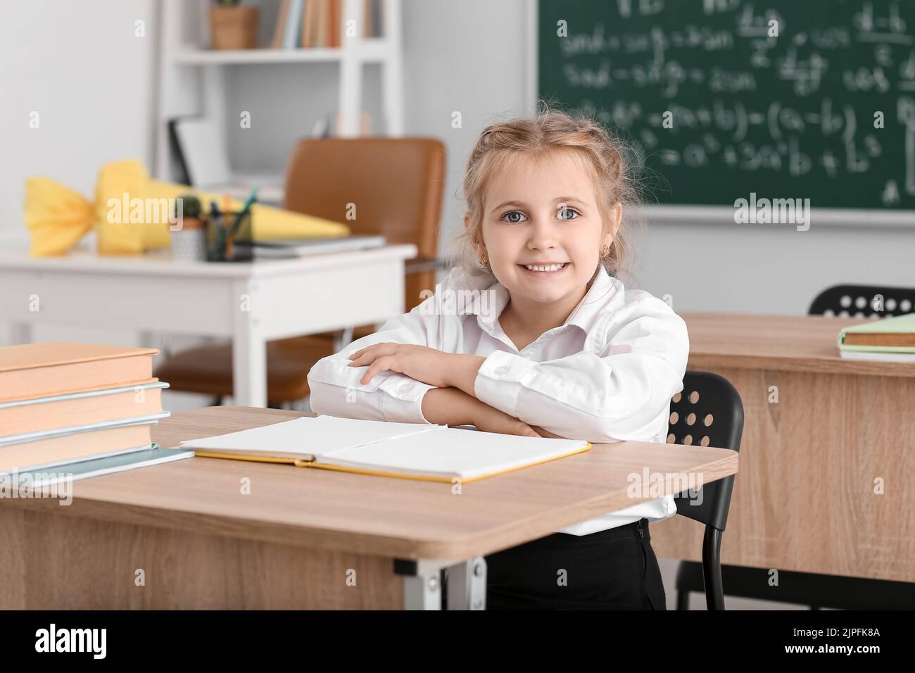 Cute little first-grader sitting at desk in classroom Stock Photo - Alamy