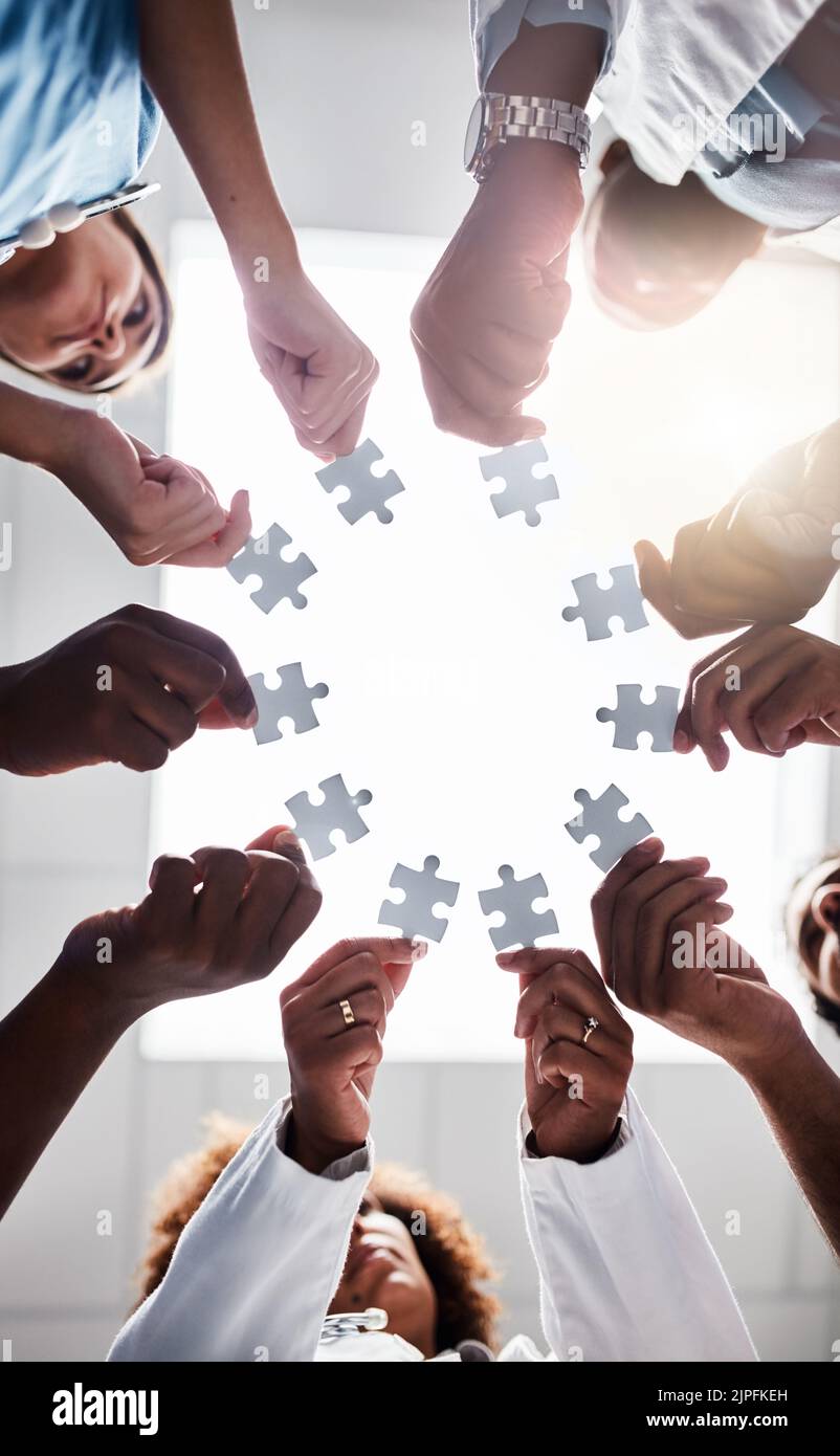 Their circle stands strong. Low angle shot of a group of doctors ...