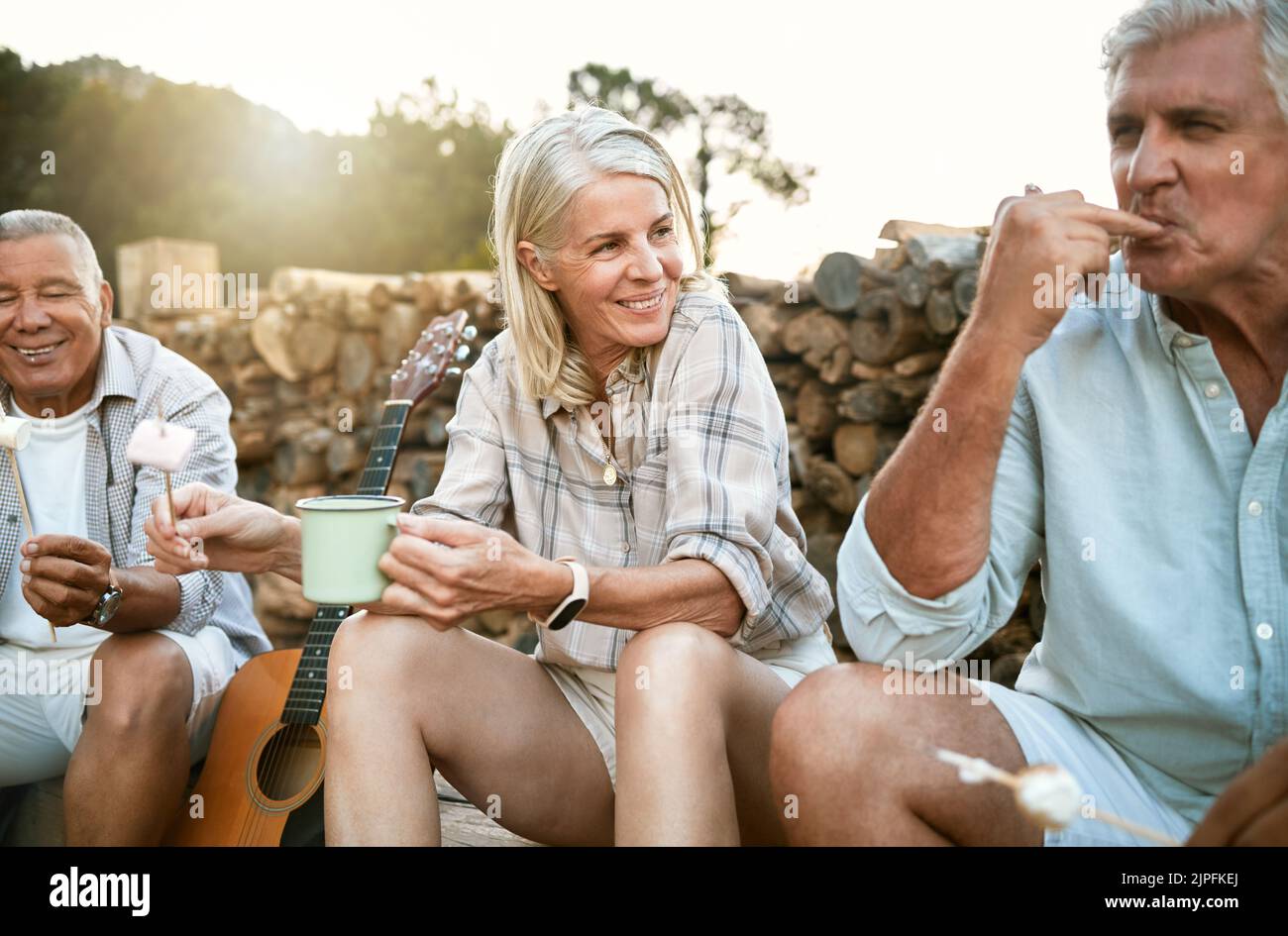 . Mature friends relaxing by fun camp while enjoying retirement, break ...