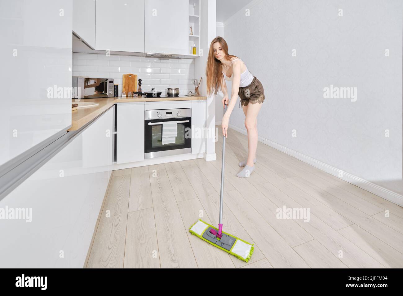 Full length of young attractive woman housewife cleaning modern ...