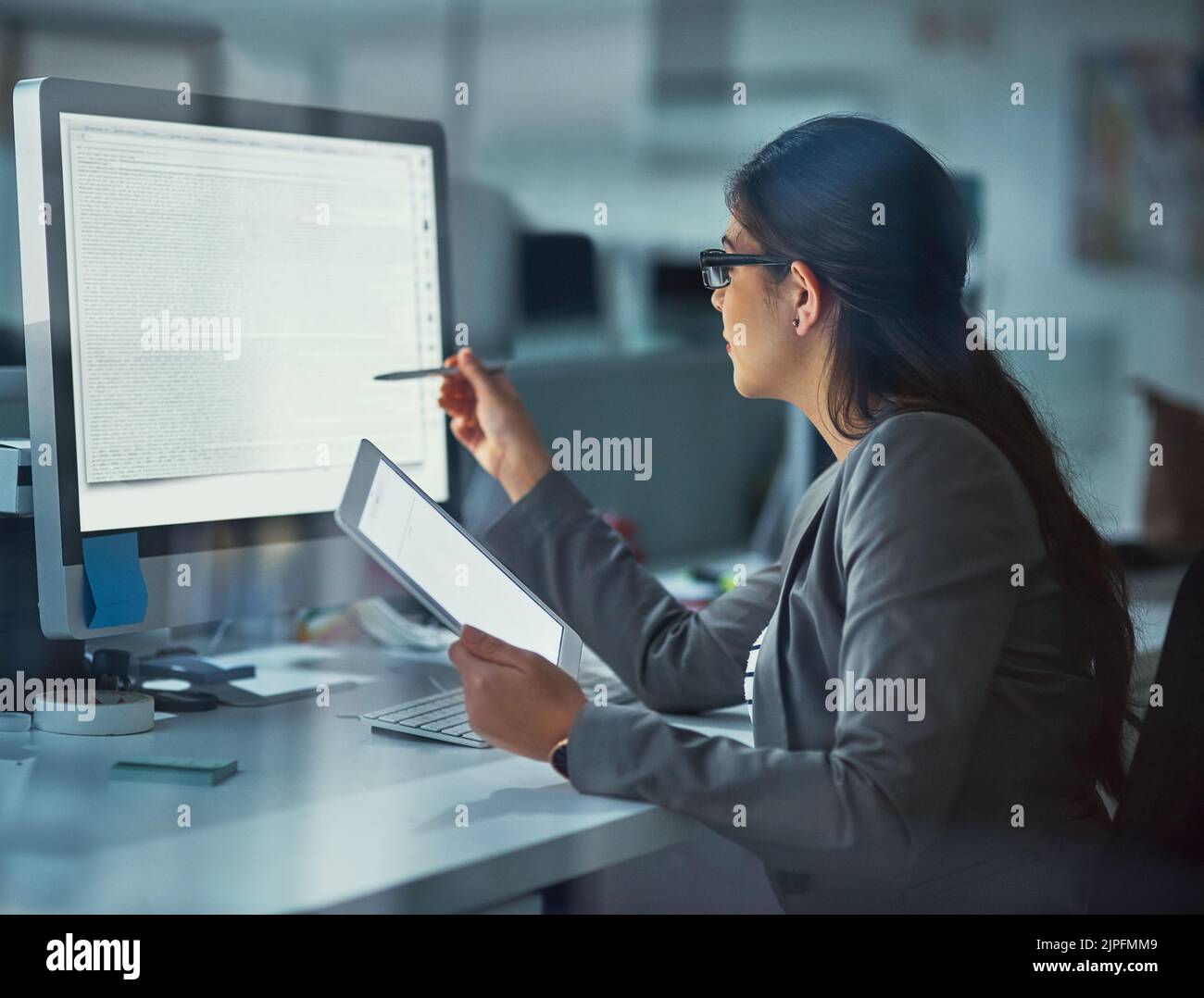Doing her double checks. a young businesswoman working late in the ...
