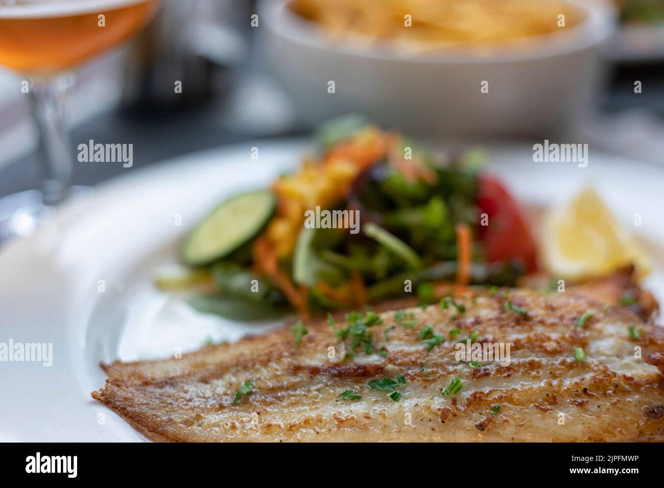 Pan fried Plaice fillet with fresh salad and a bowl of fries Stock ...