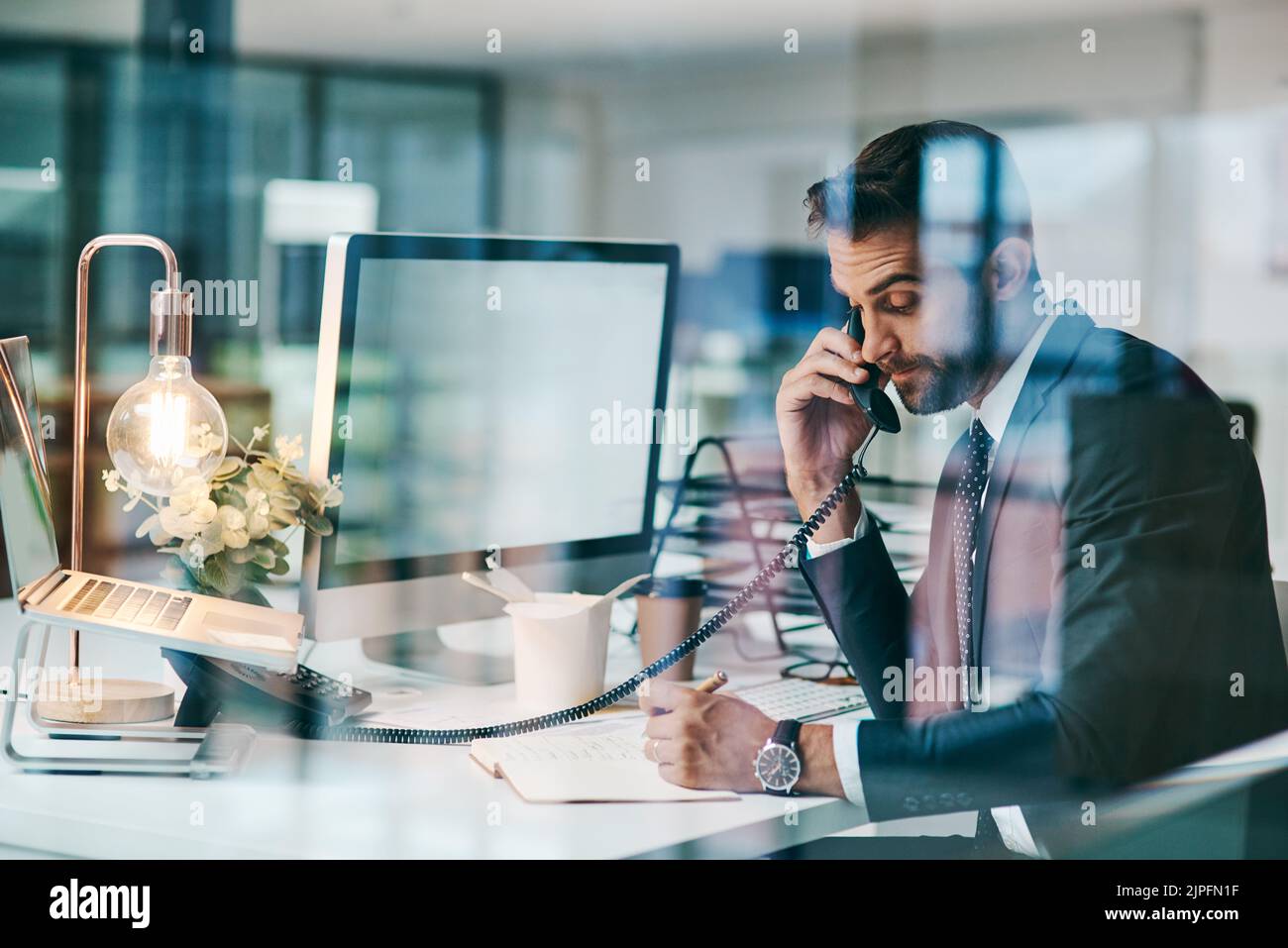 Busy with an important deal over the phone. a focused young businessman ...