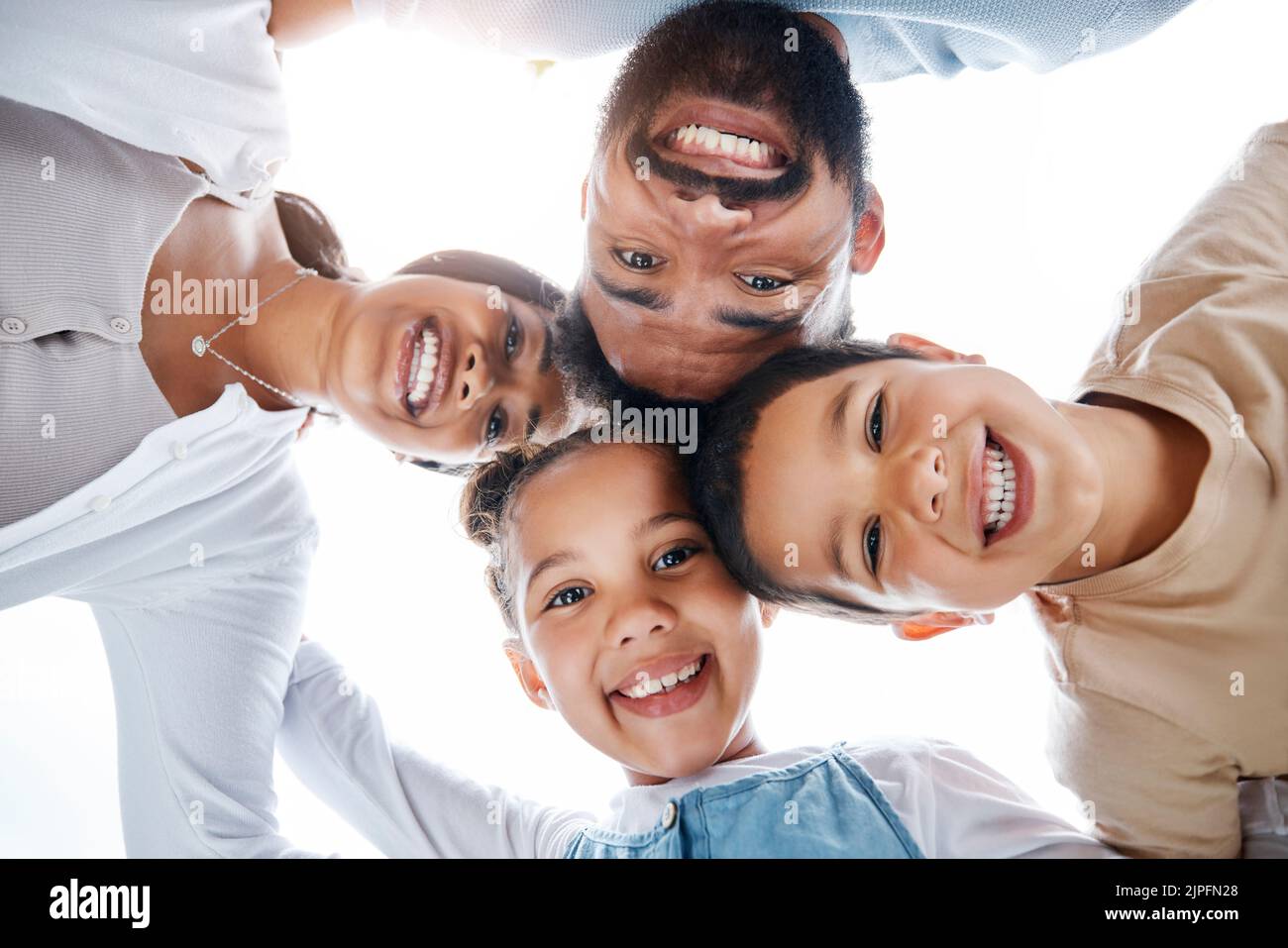 Huddled family bonding, laughing and having fun while standing in a ...
