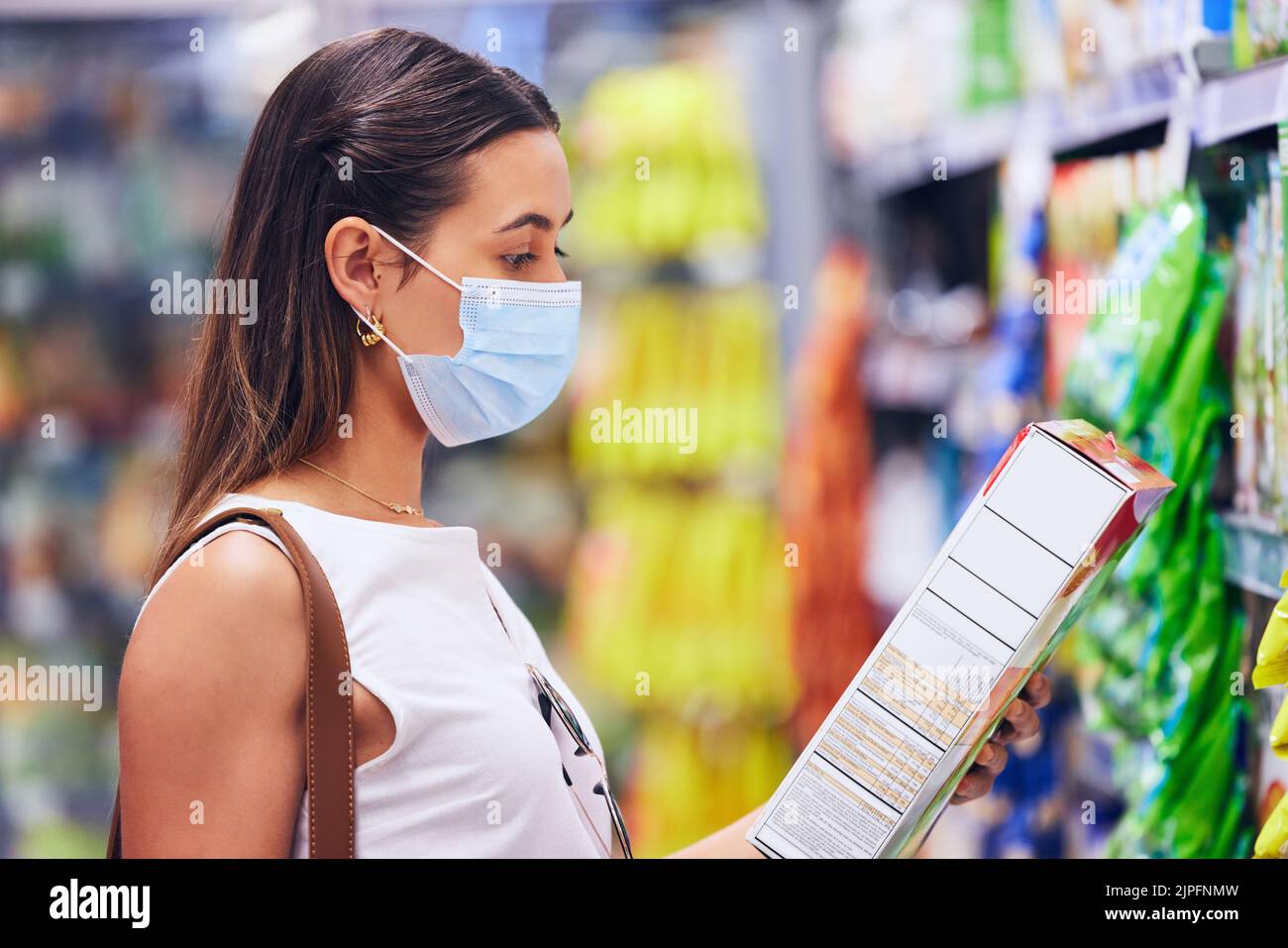 Woman reading food box information or list at the grocery store, shop ...