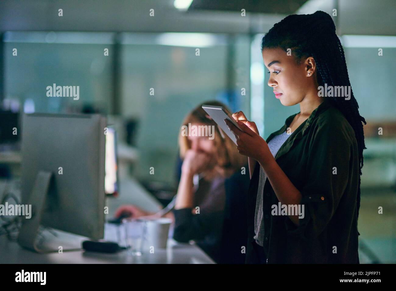 My device has all my employees tasks on it. a young businesswoman using ...