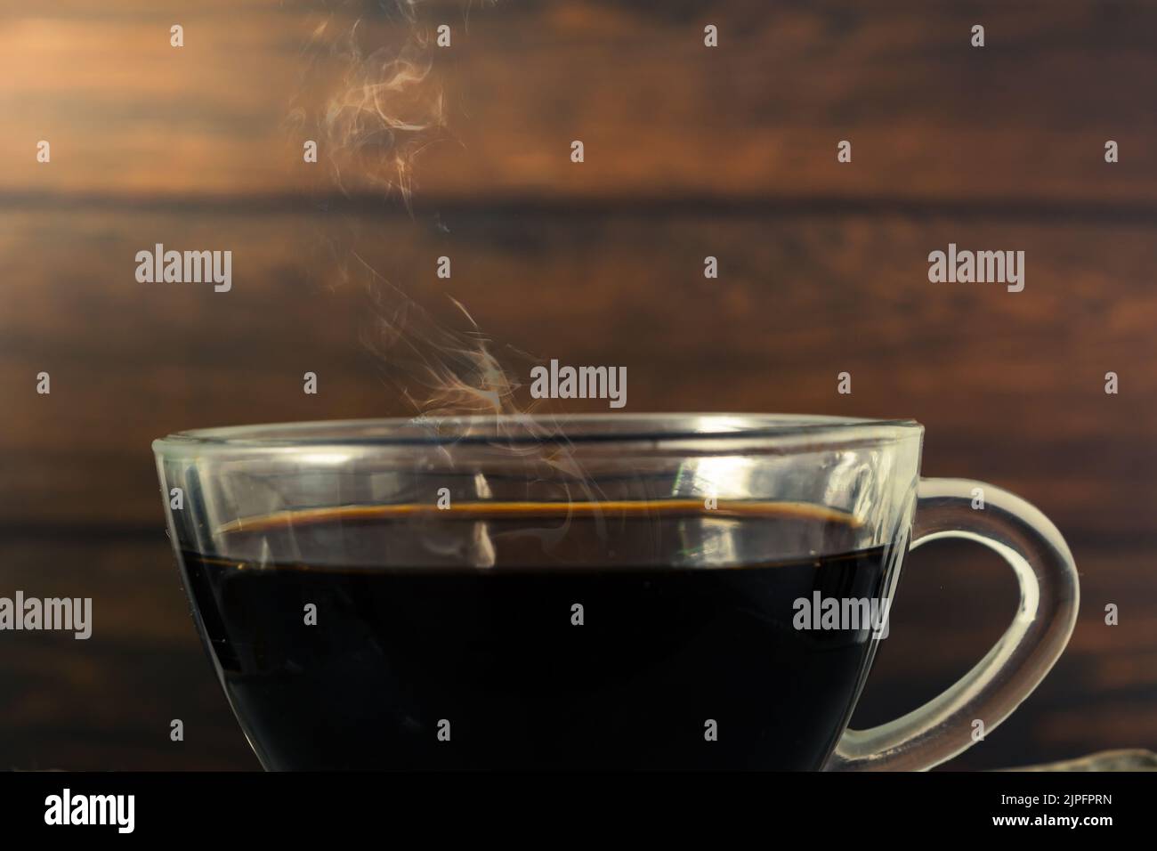glass cup with black coffee and hot smoke on wooden background Stock ...