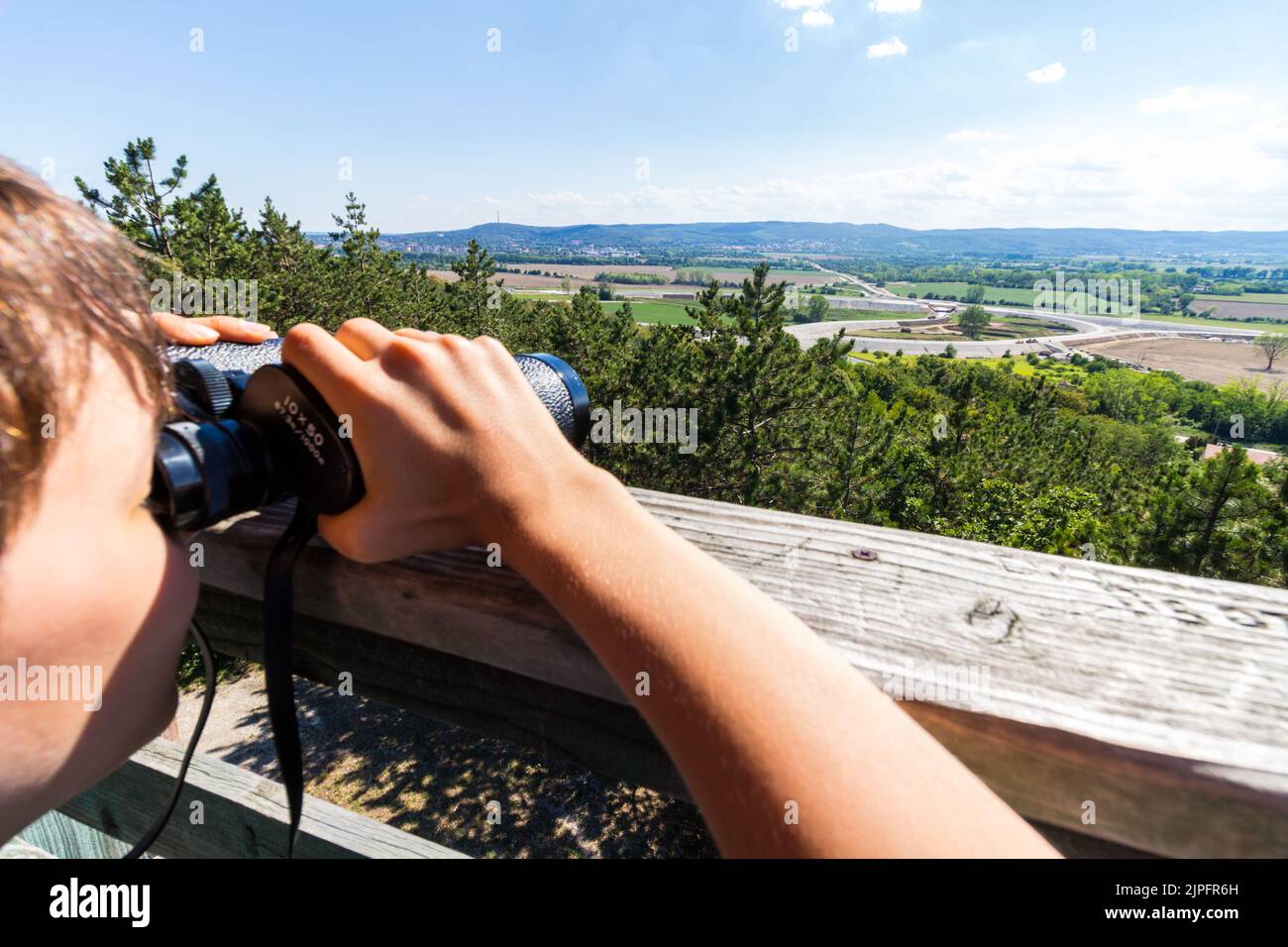 Boy child looking through binoculars on top of Hubertus lookout tower ...