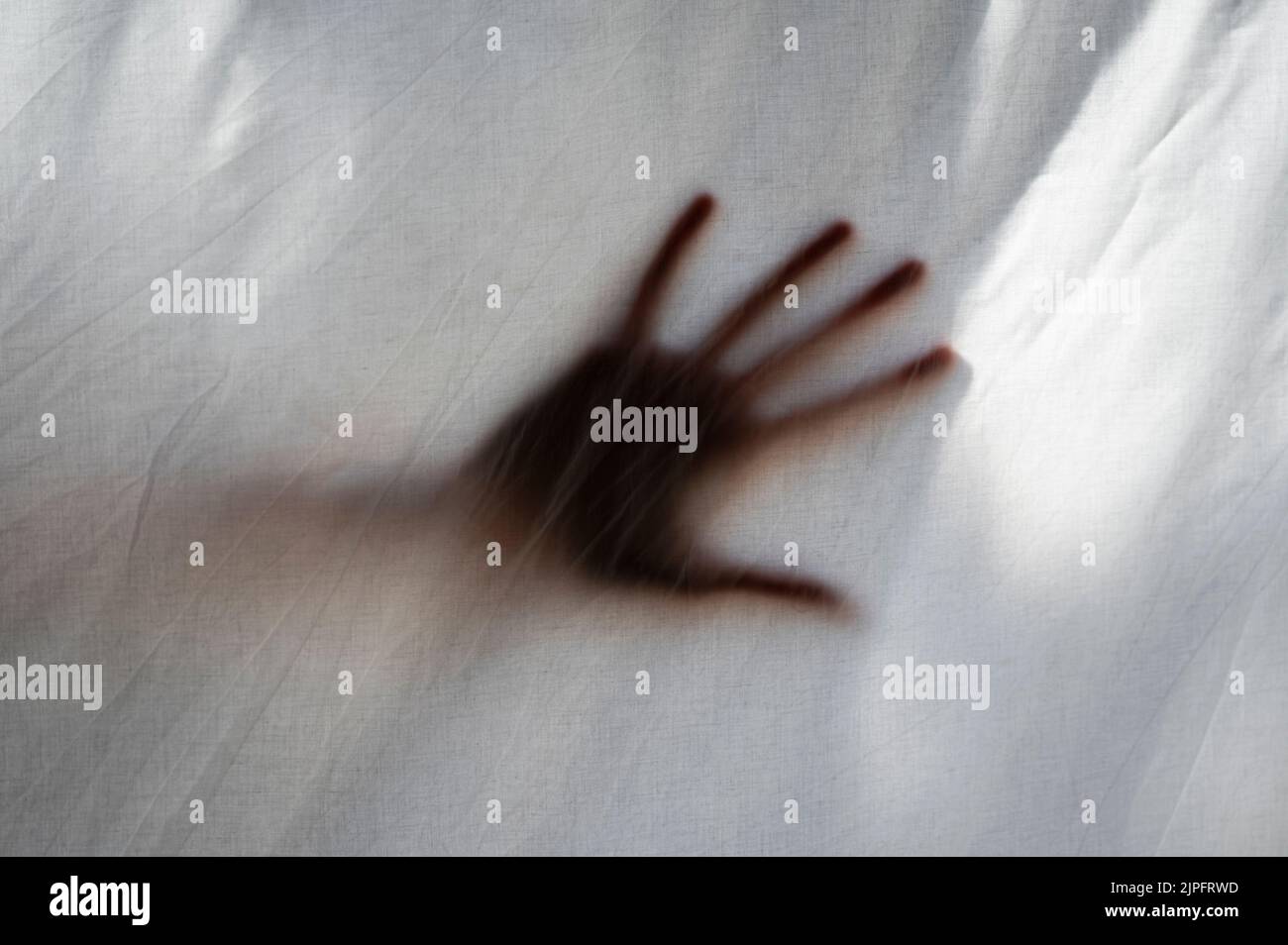 Hand shade behind white sheet Stock Photo - Alamy