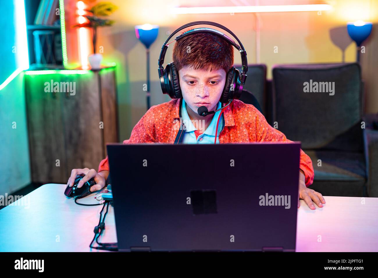 Teenager kid with headphones seriously playing online video game on ...