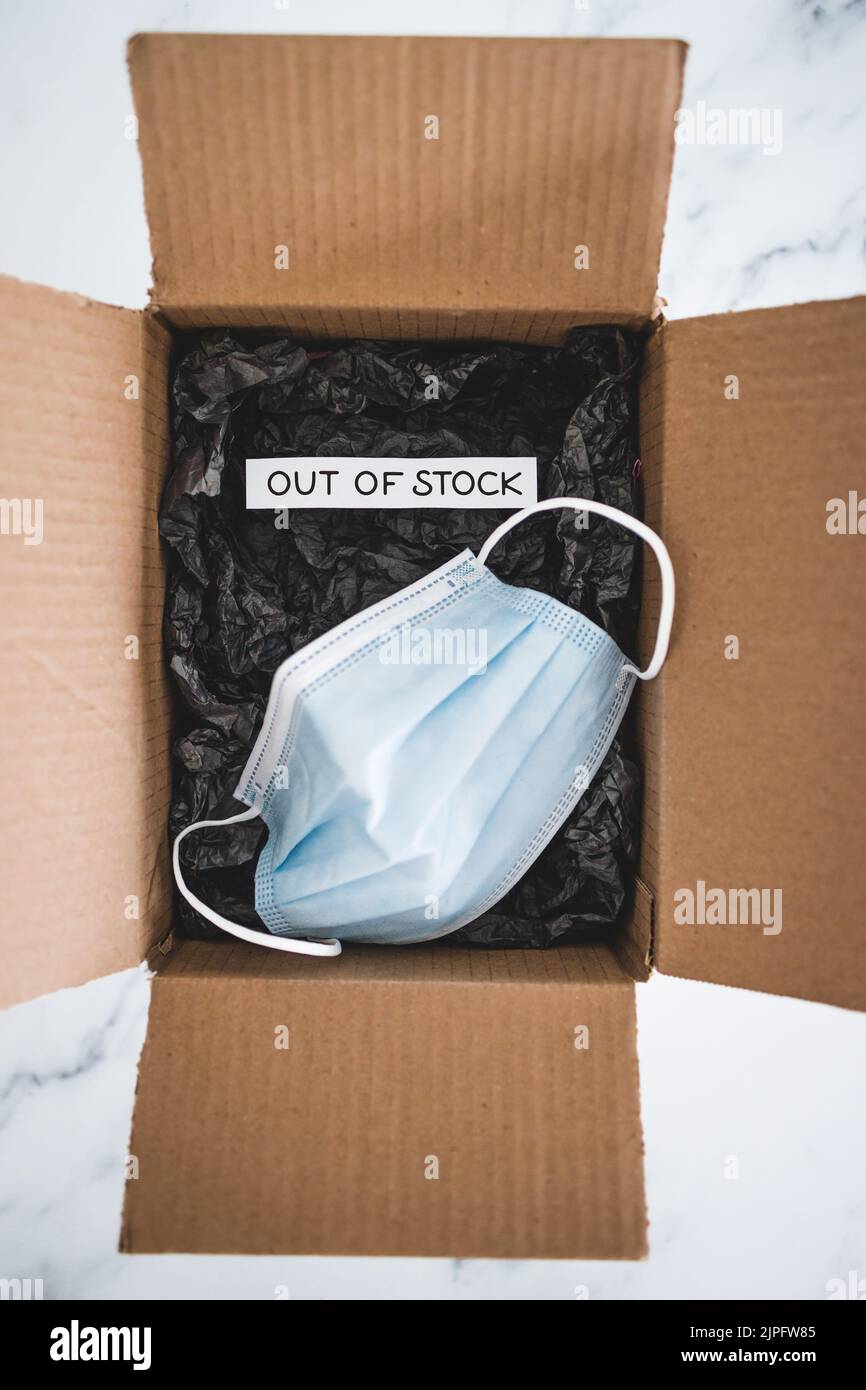 Out of stock text inside of empty delivery parcel with surgical mask on ...