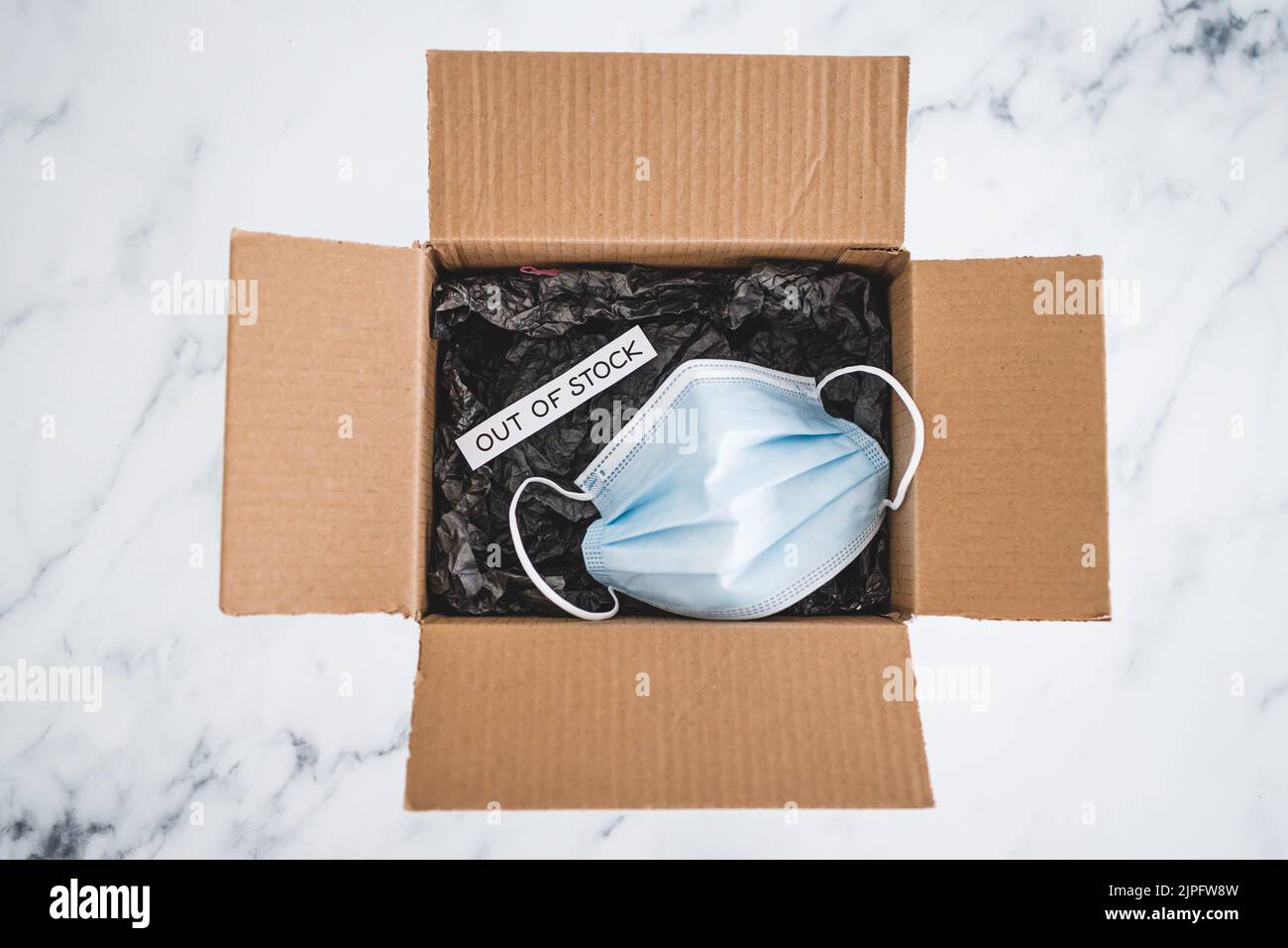 Out of stock text inside of empty delivery parcel with surgical mask on ...