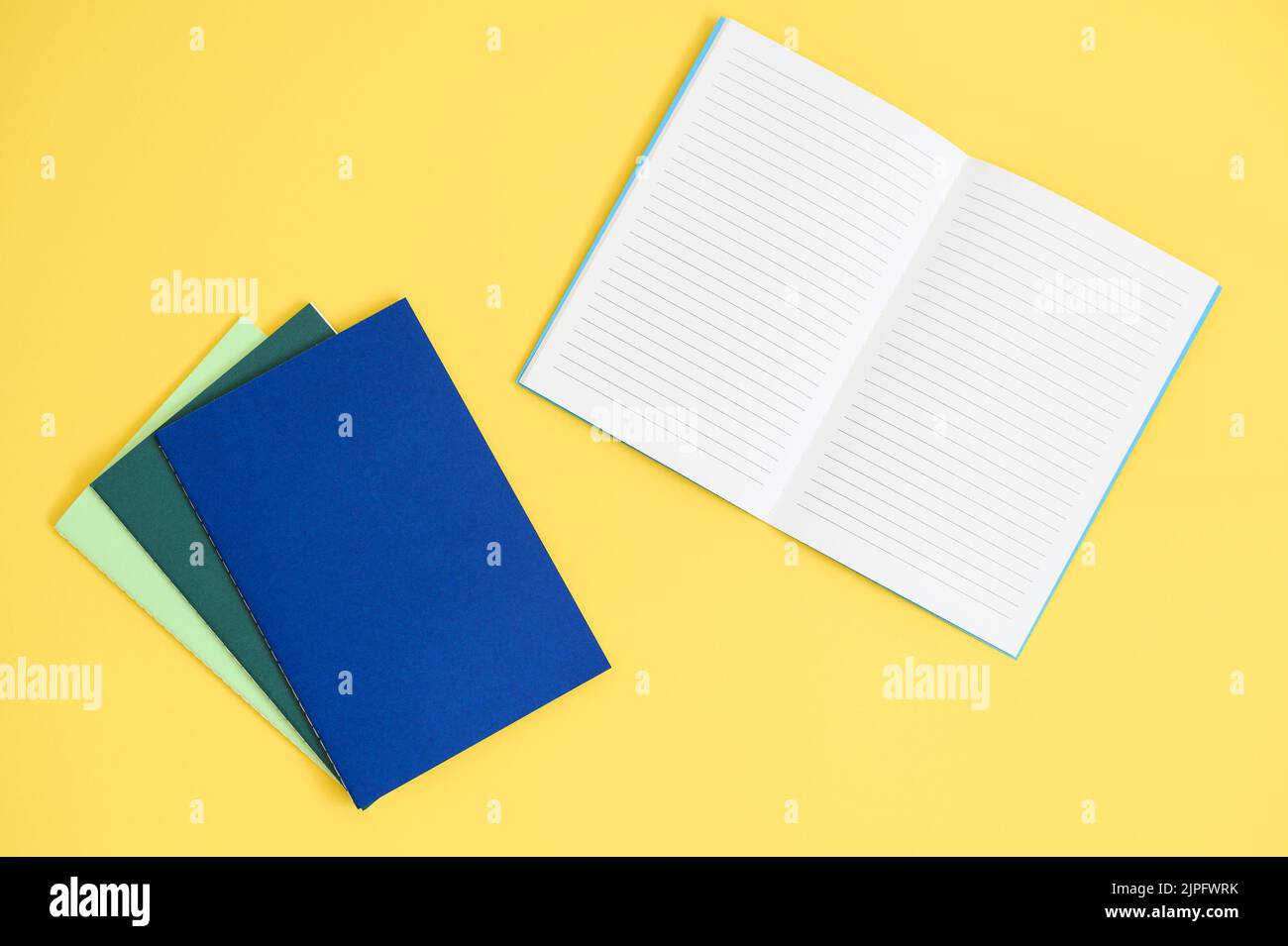 notebook on bright yellow background from above Stock Photo - Alamy