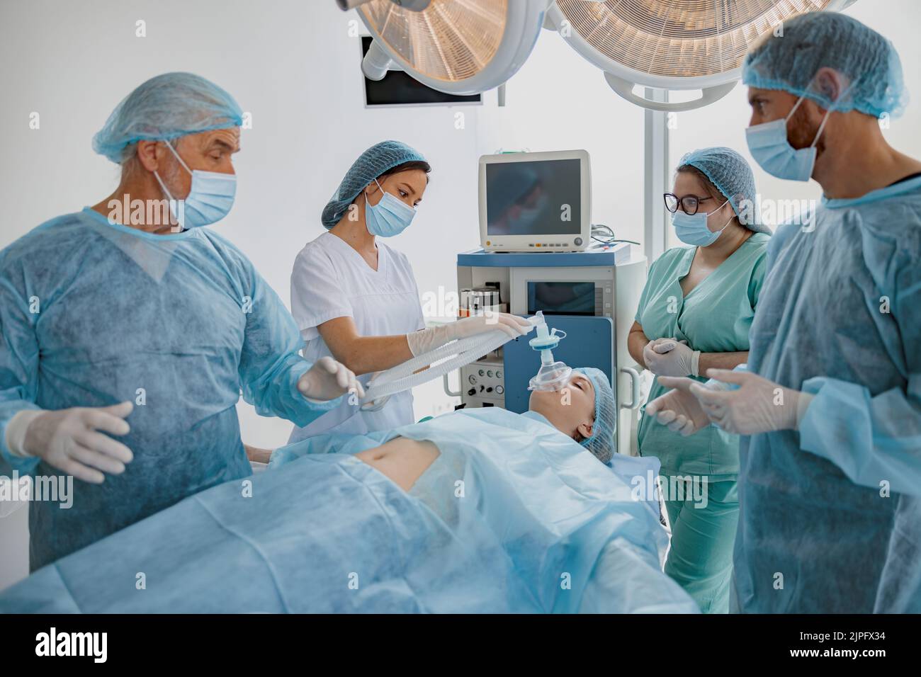 Concentrated surgical team working with patient in operation room ...