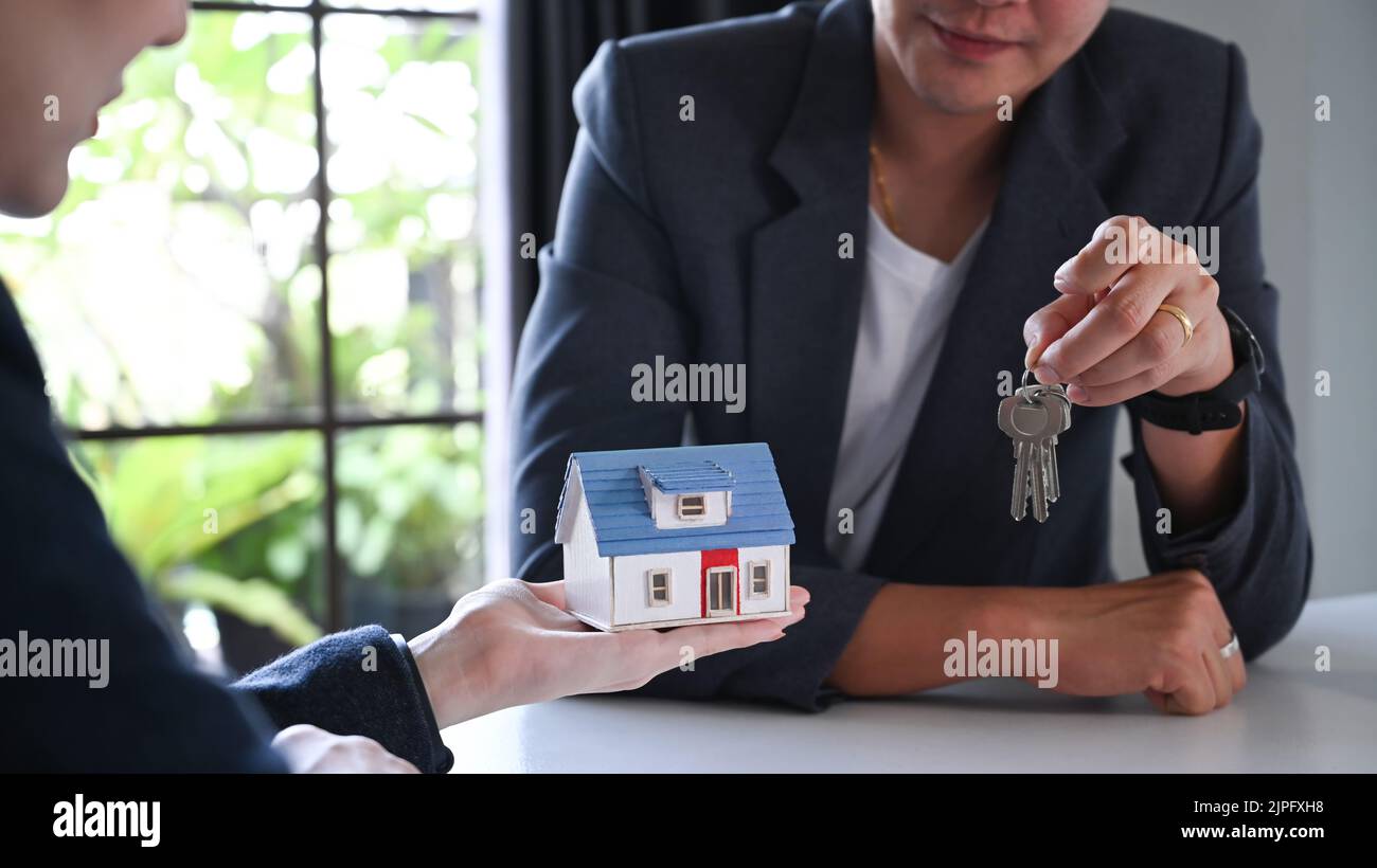 Cropped view of male real estate agent giving keys of new house to ...