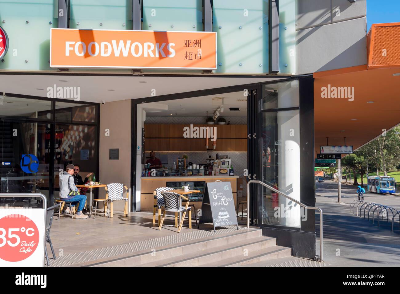 A Foodworks mini supermarket and cafe with a multilingual sign in ...