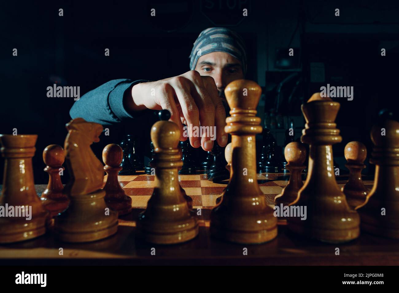 Young adult handsome man playing chess in dark with side lit Stock ...