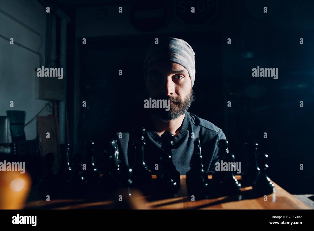 Young adult handsome man playing chess in dark. Chess figures and male ...