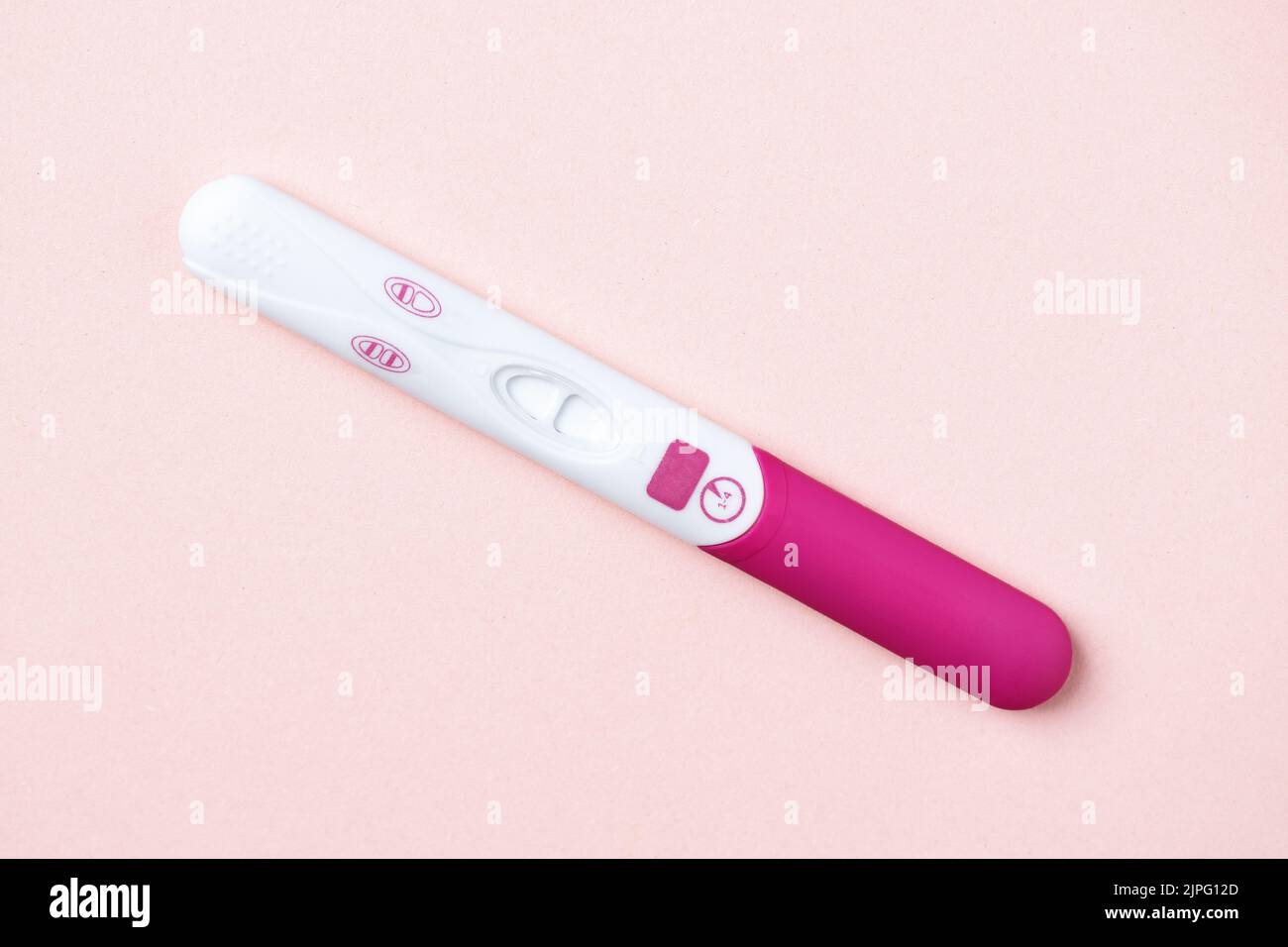 Pink positive pregnancy test on pink background. Positive result of ...