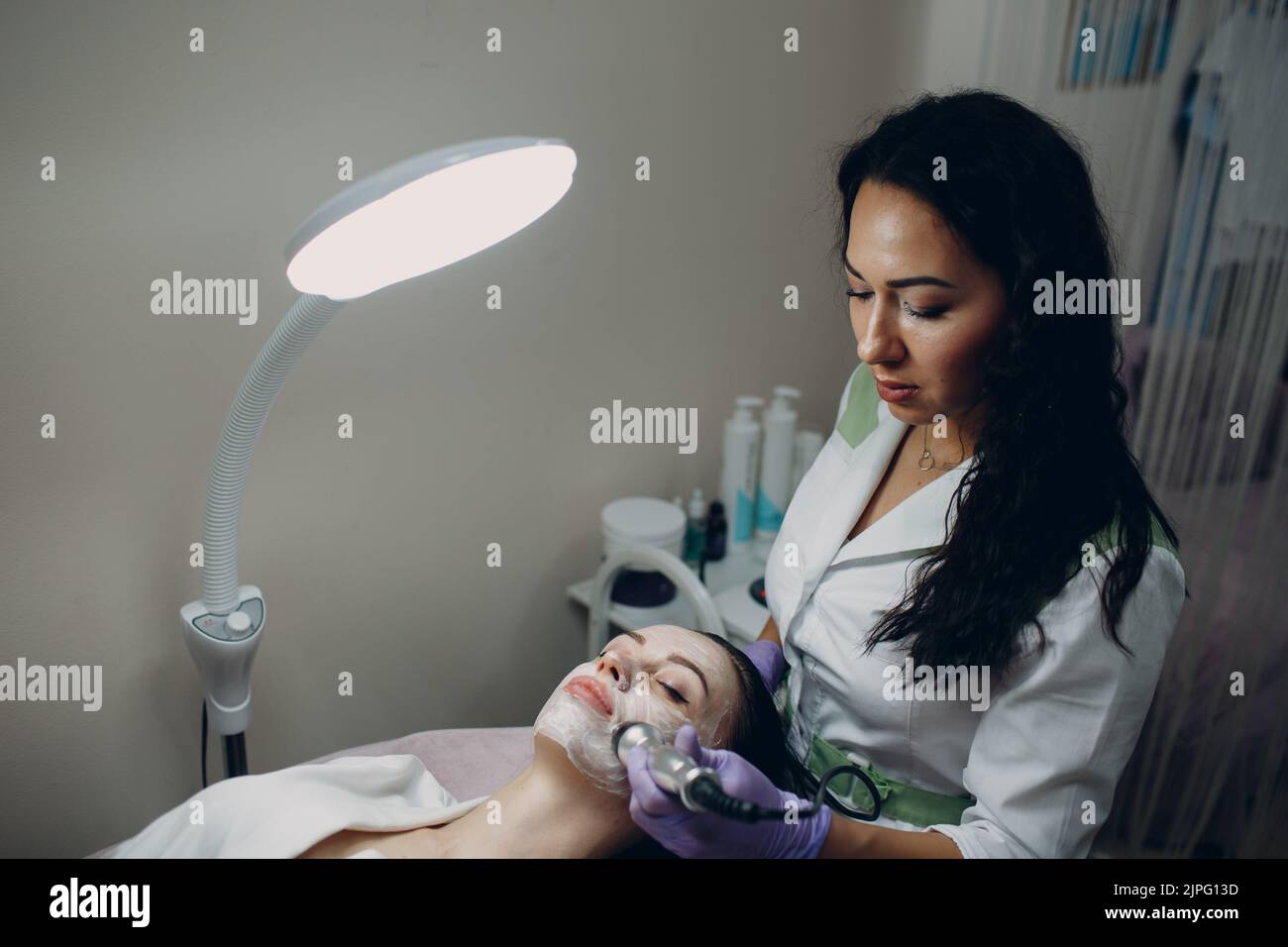 Young woman receiving electric RF lifting facial massage at beauty spa ...