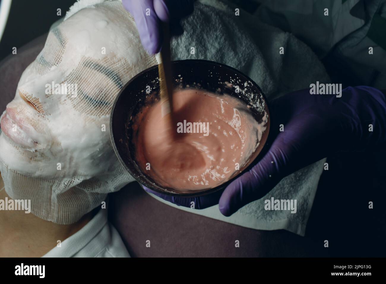 The process of preparation of pink alginate mask for face. Cup in the ...