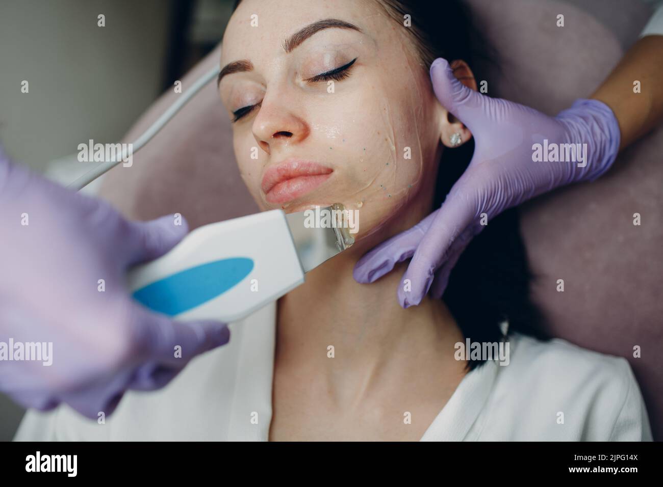 Woman receiving cleansing therapy with a professional ultrasonic equipment in cosmetology beauty ...