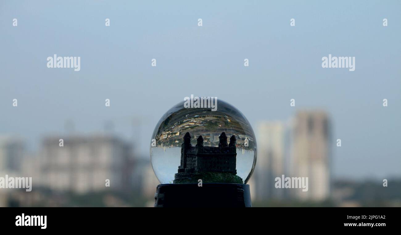 Small castle in gift glass ball in front of modern city buildings with ...