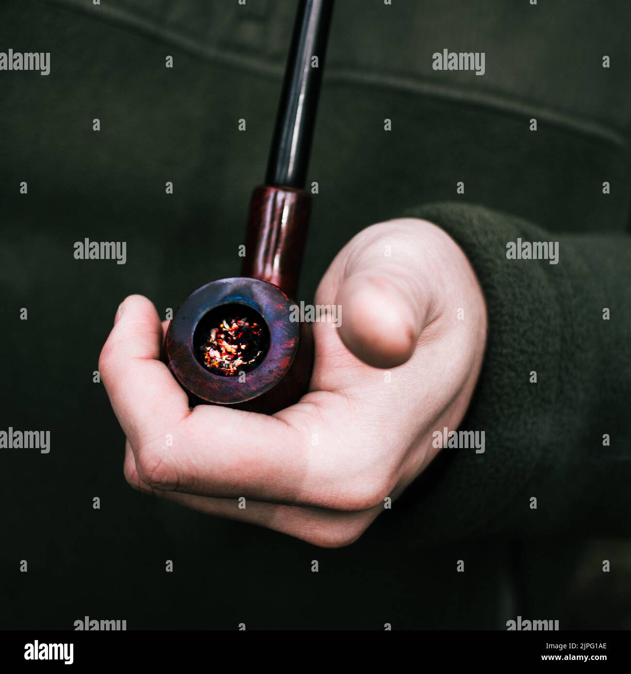 The close-up view of a retro smoking pipe in the left hand Stock Photo ...